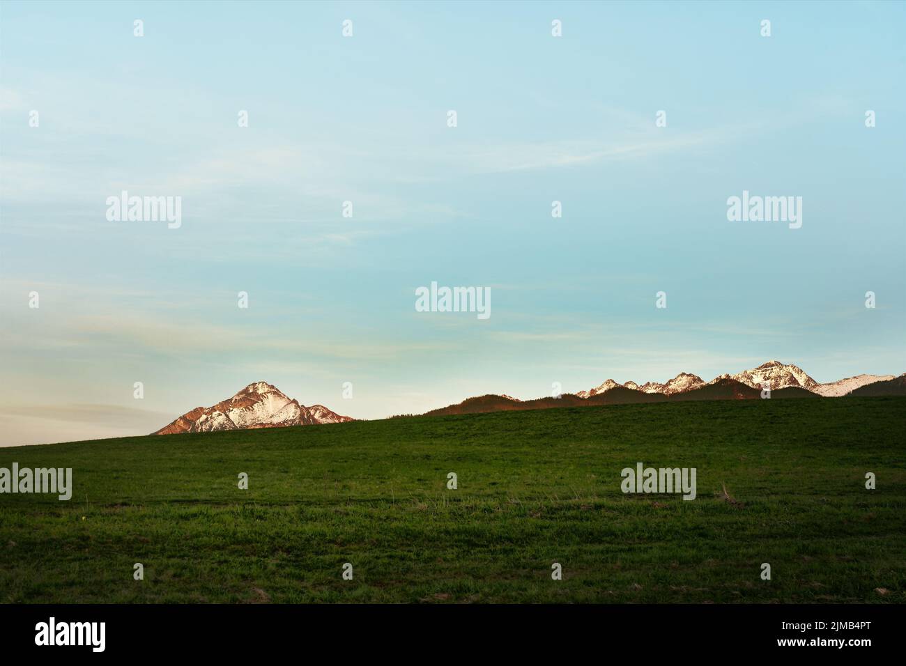 A beautiful view of Tatry Mountains against the blue sky with a green ...