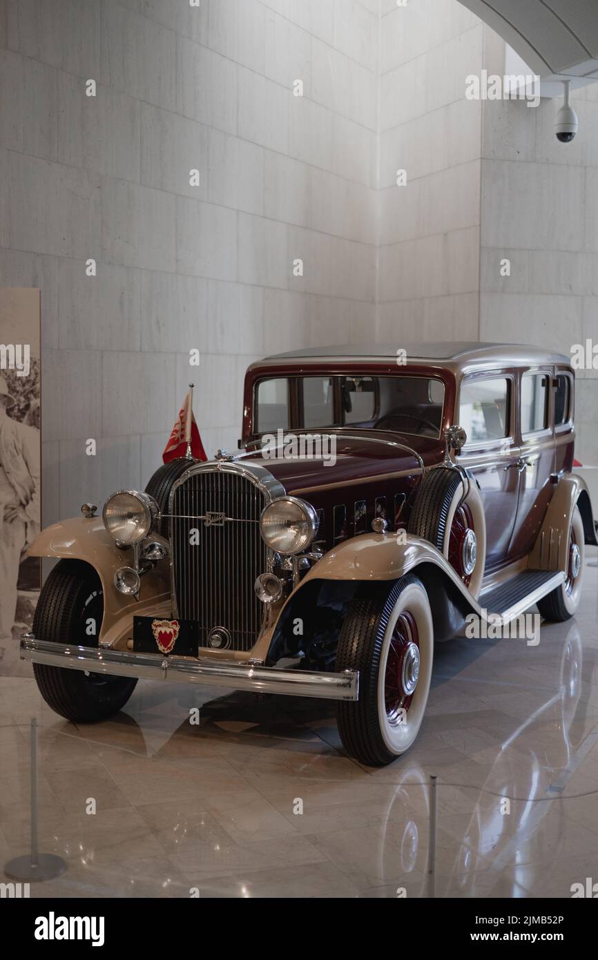 A vertical shot of a brown Buick classic car in the Bahrain museum ...