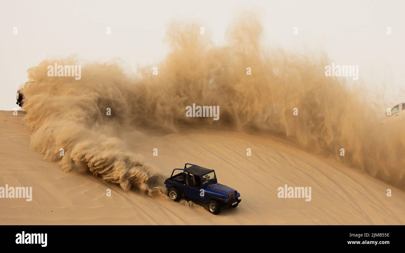 An aerial shot of an off-road Jeep showing up on a desert sand Stock ...