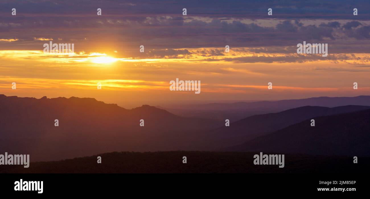 A mesmerizing view of a golden sunset over mountains Stock Photo - Alamy
