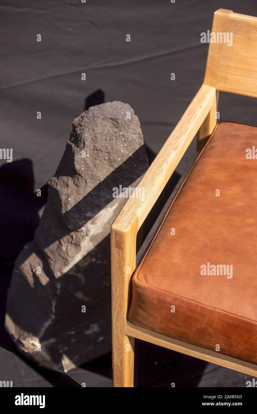 A minimalistic vertical shot of a chair with a rock Stock Photo - Alamy