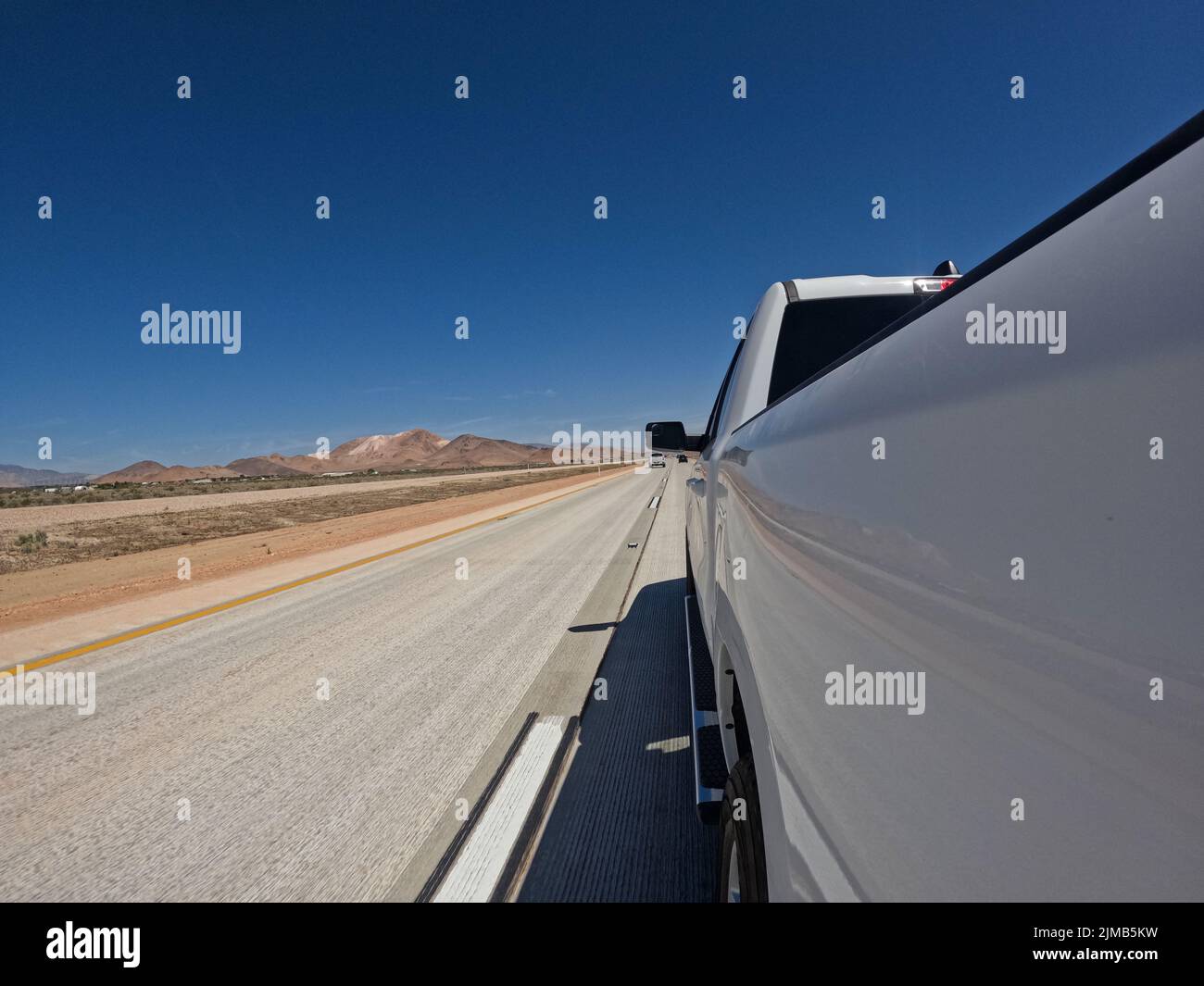 A grey pick up truck driving fast in the desert Stock Photo - Alamy