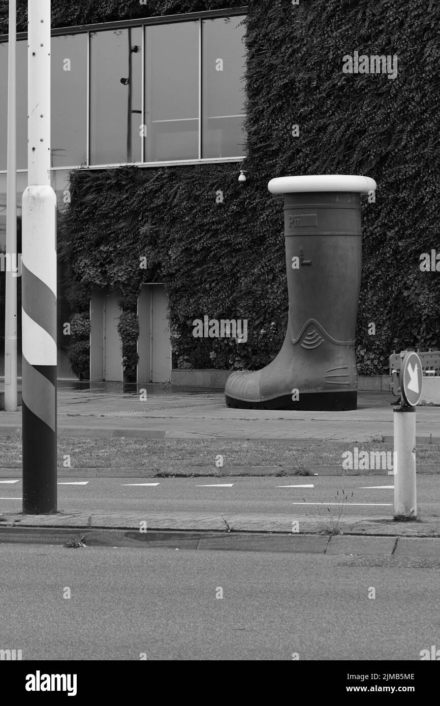 A grayscale shot of an art installation, giant rubber boots at the ...