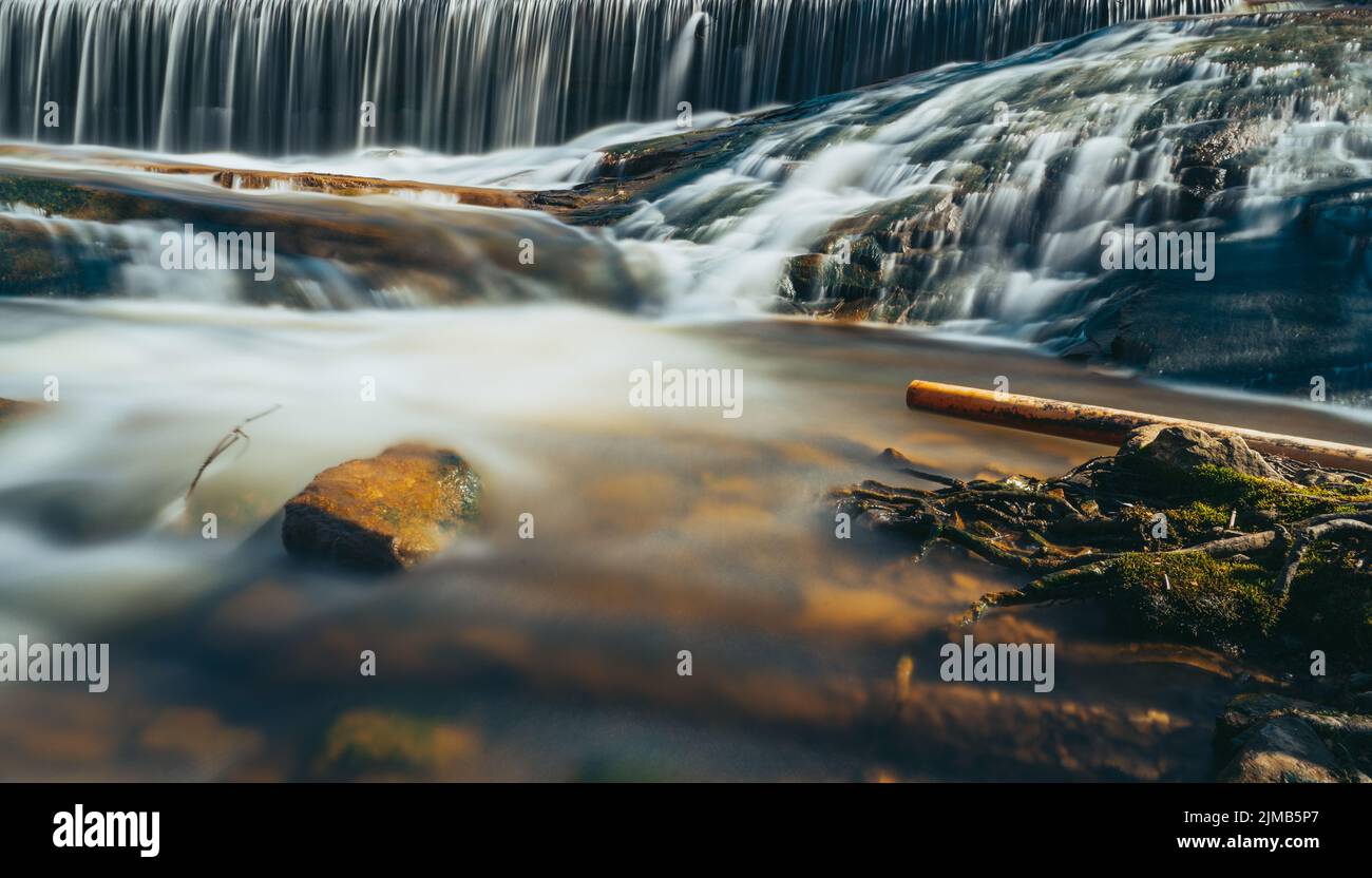 A beautiful waterfall flowing into the river at Atlanta Waterfalls park ...