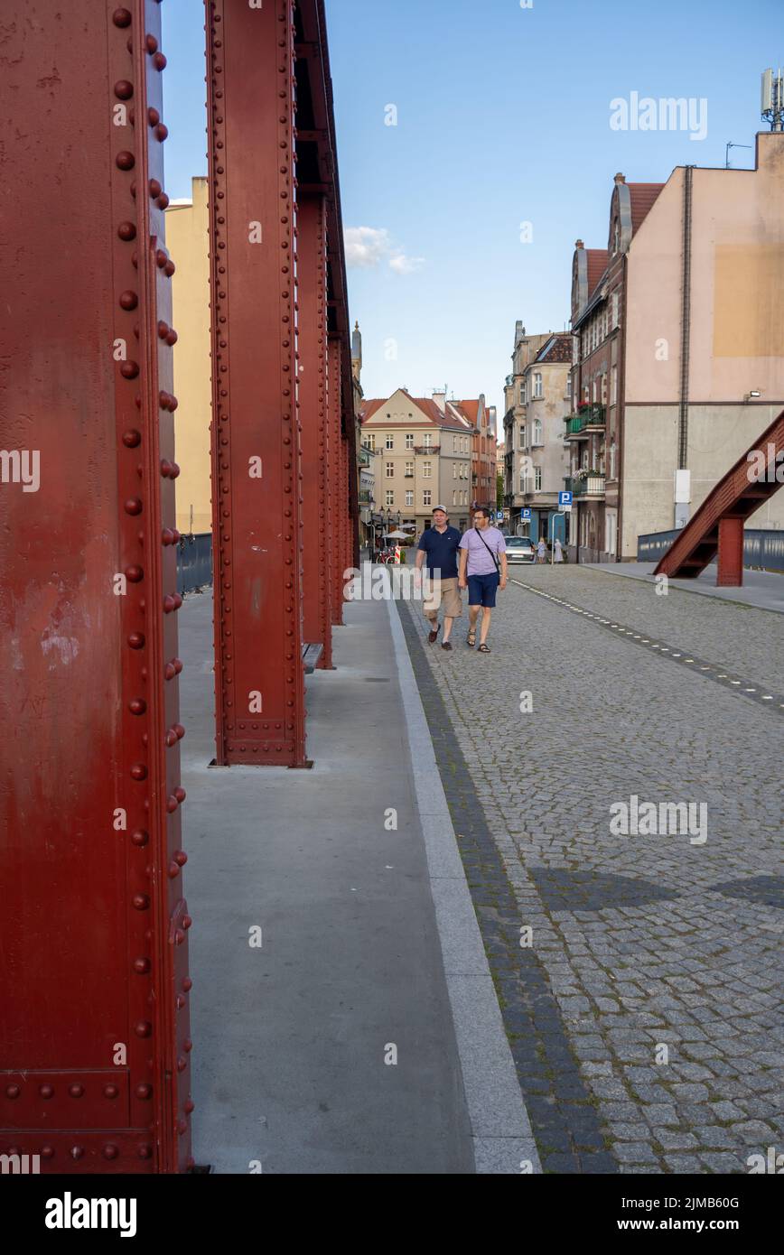 A vertical shot of two people walking on the Jordan bridge with a red ...