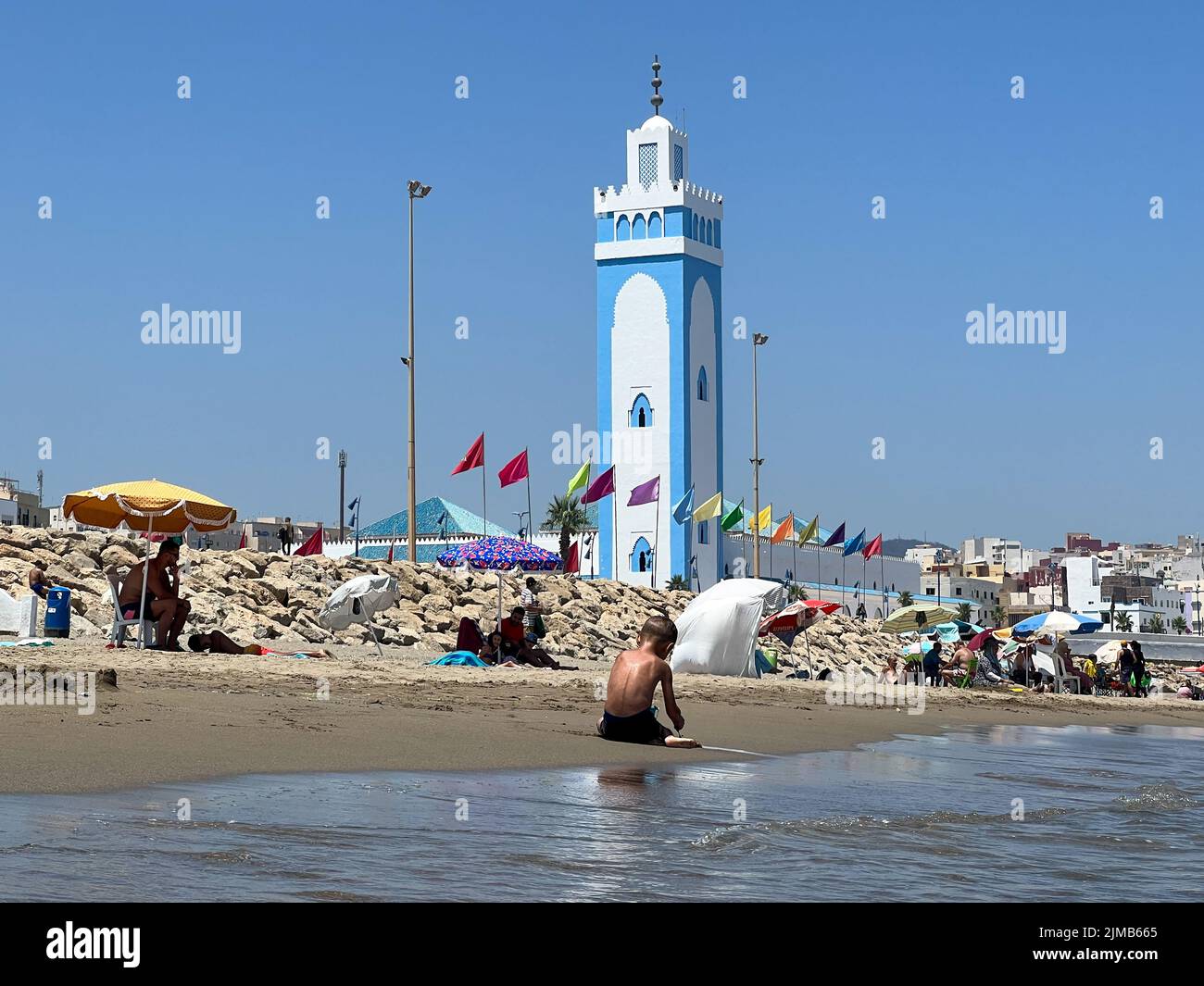 A crowd of people enjoying their summer holiday on the beach nearby ...