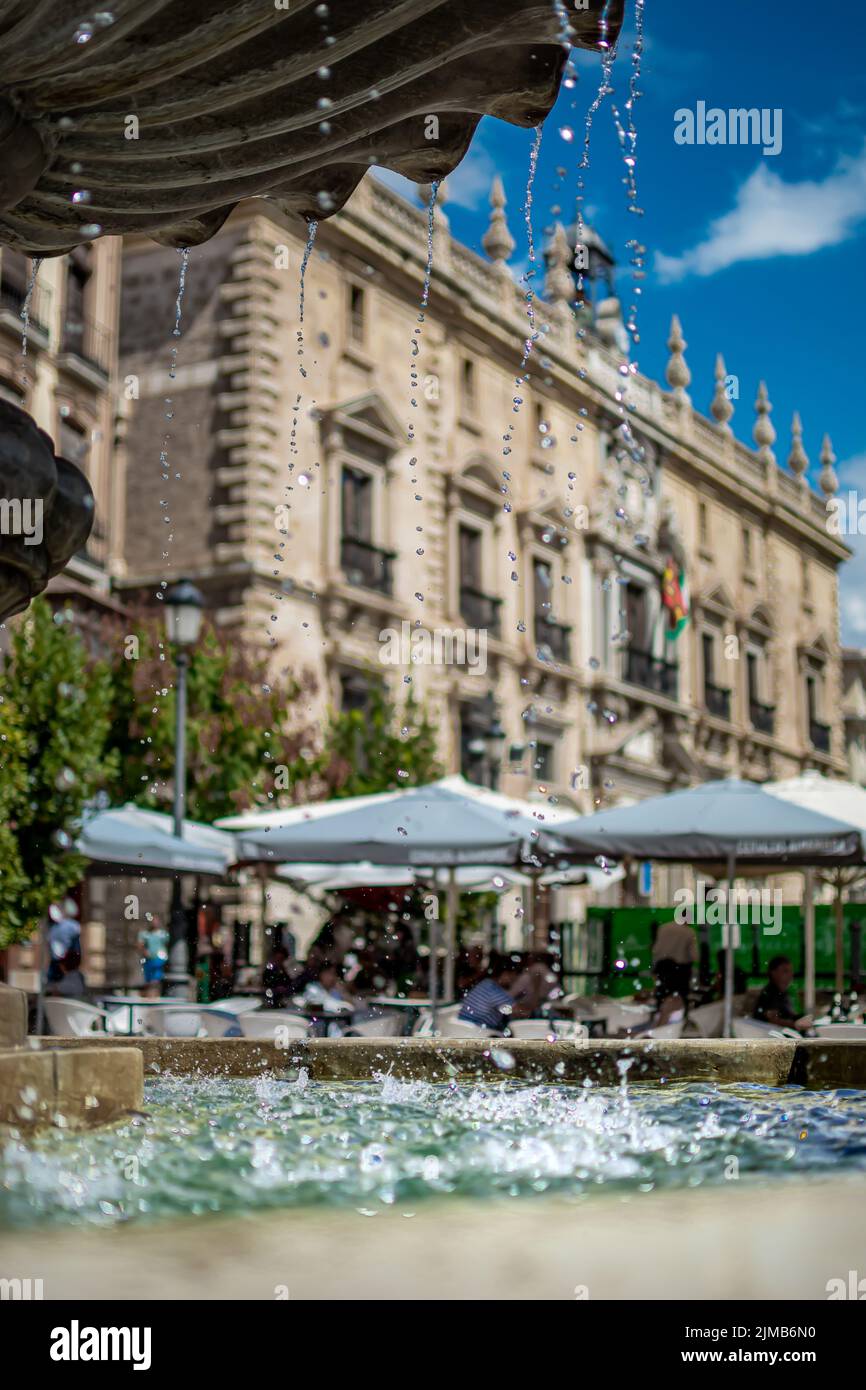A vertical closeup shot of water drops flowing down the fountain with ...