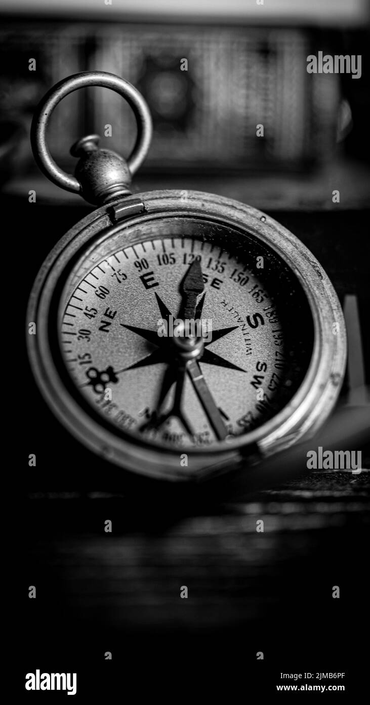A grayscale vertical closeup of a compass Stock Photo - Alamy