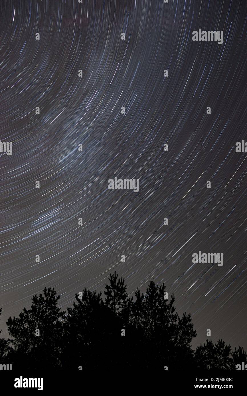 A vertical shot of star trails around the pole star Stock Photo - Alamy