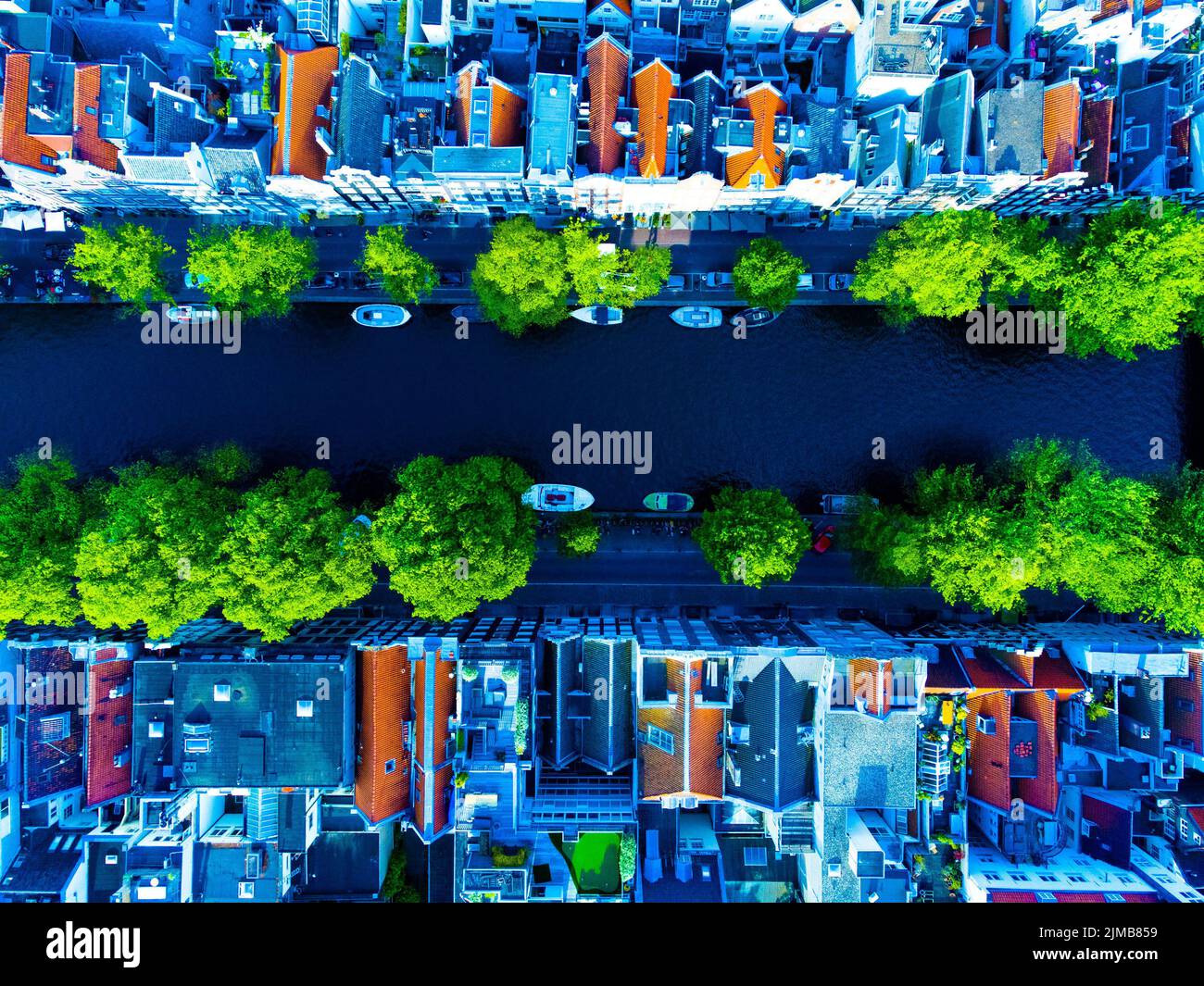 An aerial view of a river with parked boats in between city buildings ...