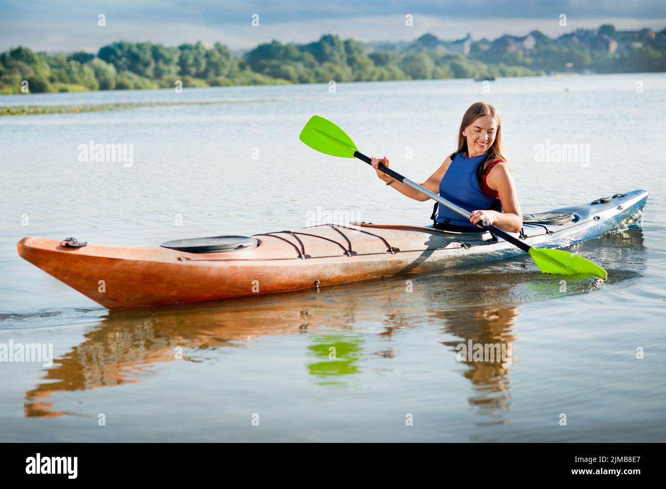 tourist woman paddling kayak alone on lake. A girl goes on a water ...