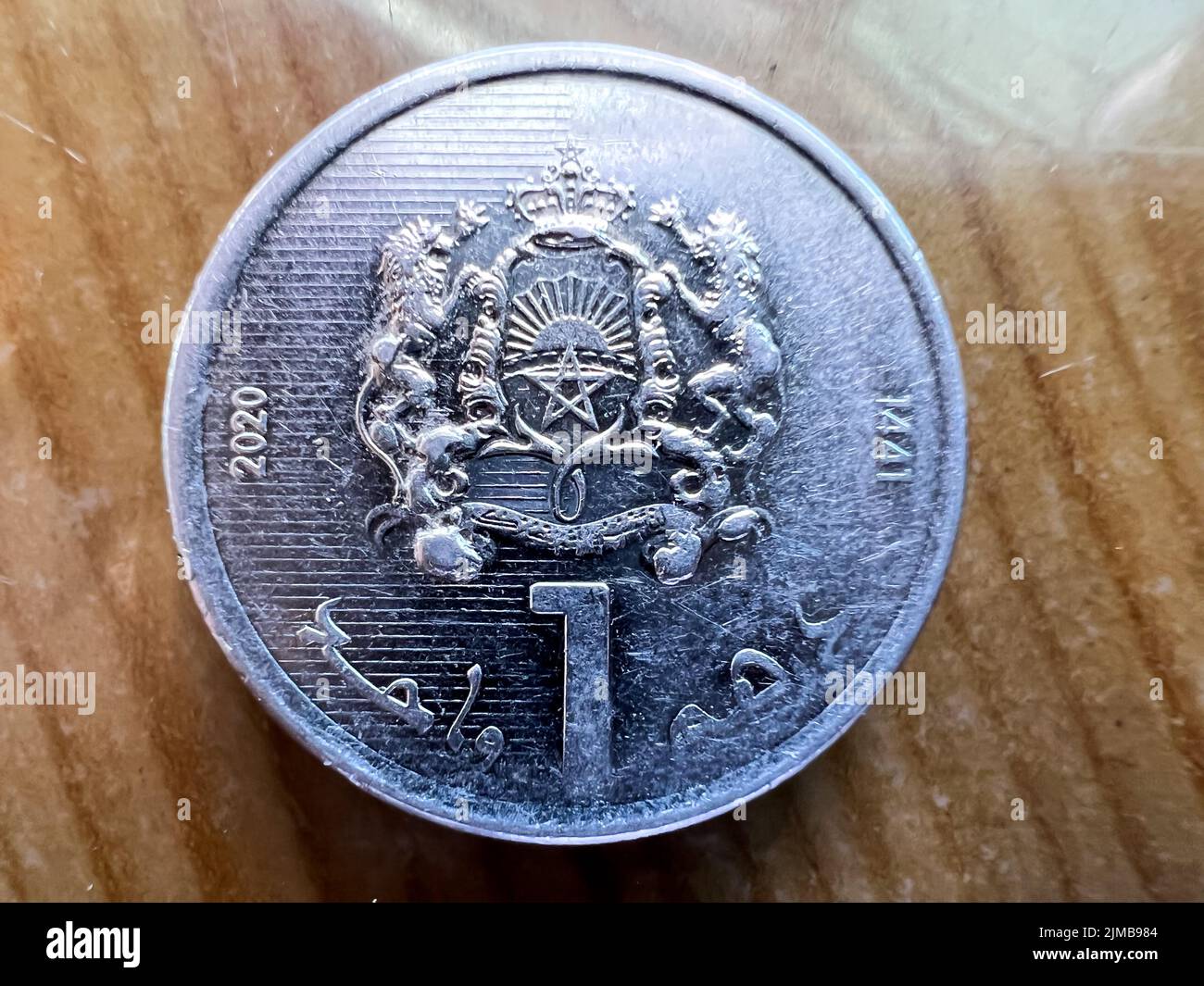 A closeup of a Moroccan Dirham coin on a brown table Stock Photo - Alamy
