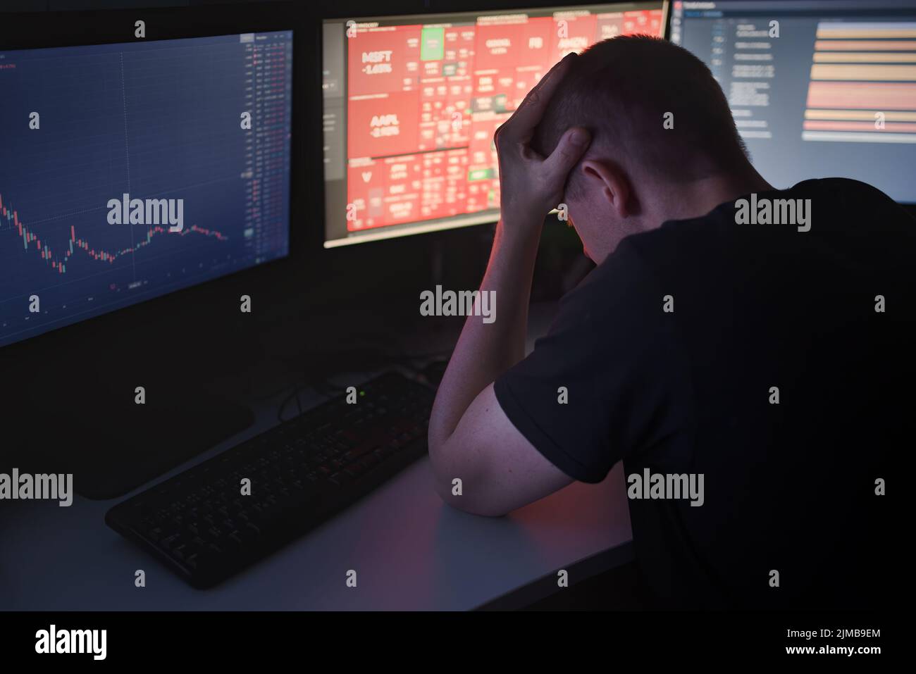 An unhappy man holding his head as he watches the stock market plunge ...