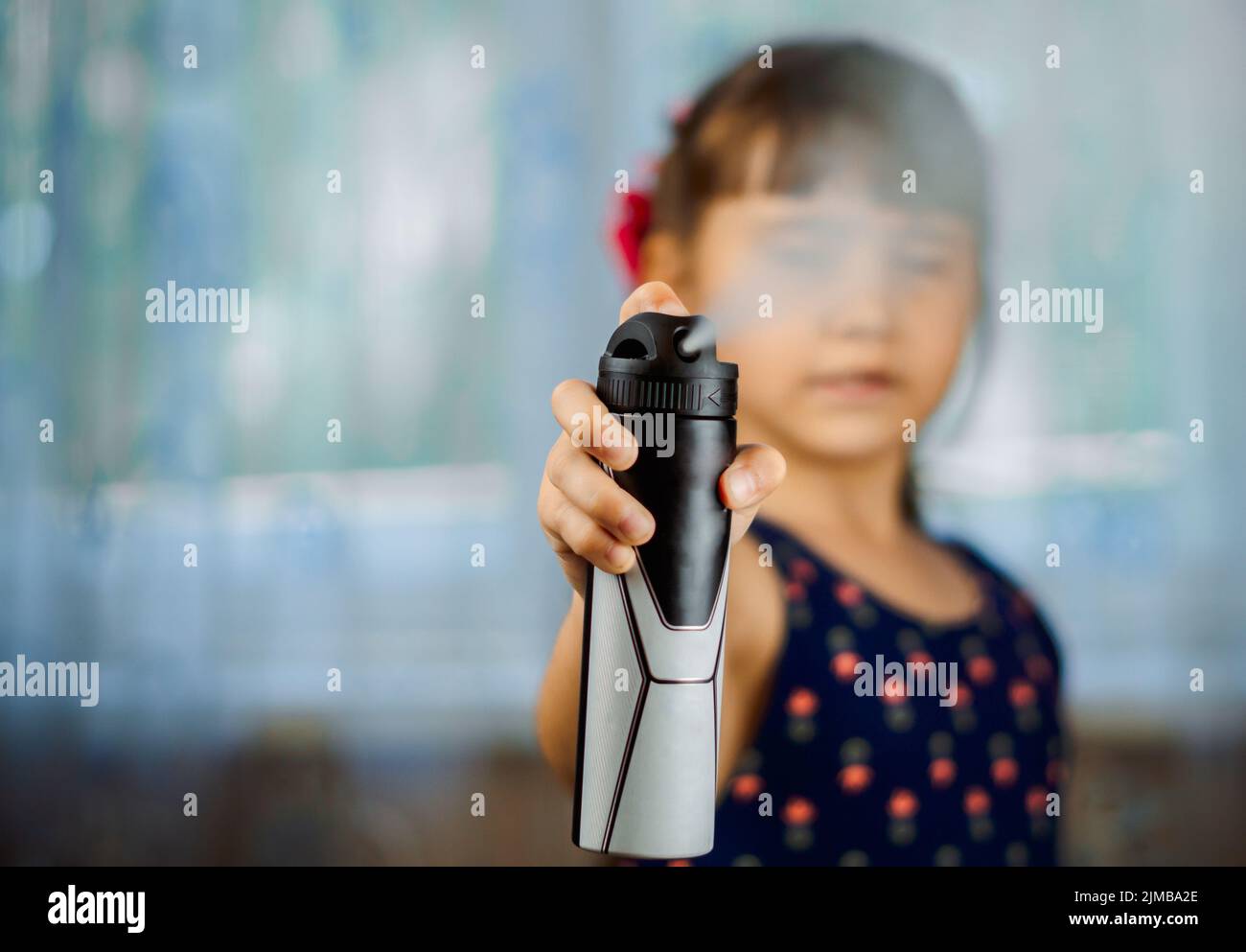 A little girl using gas spray. Safety measures for kids Stock Photo - Alamy