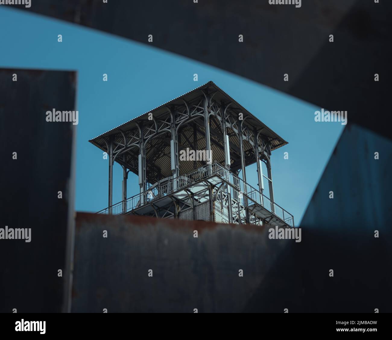 A low angle shot of an abandoned prison tower behind taken from a steel ...