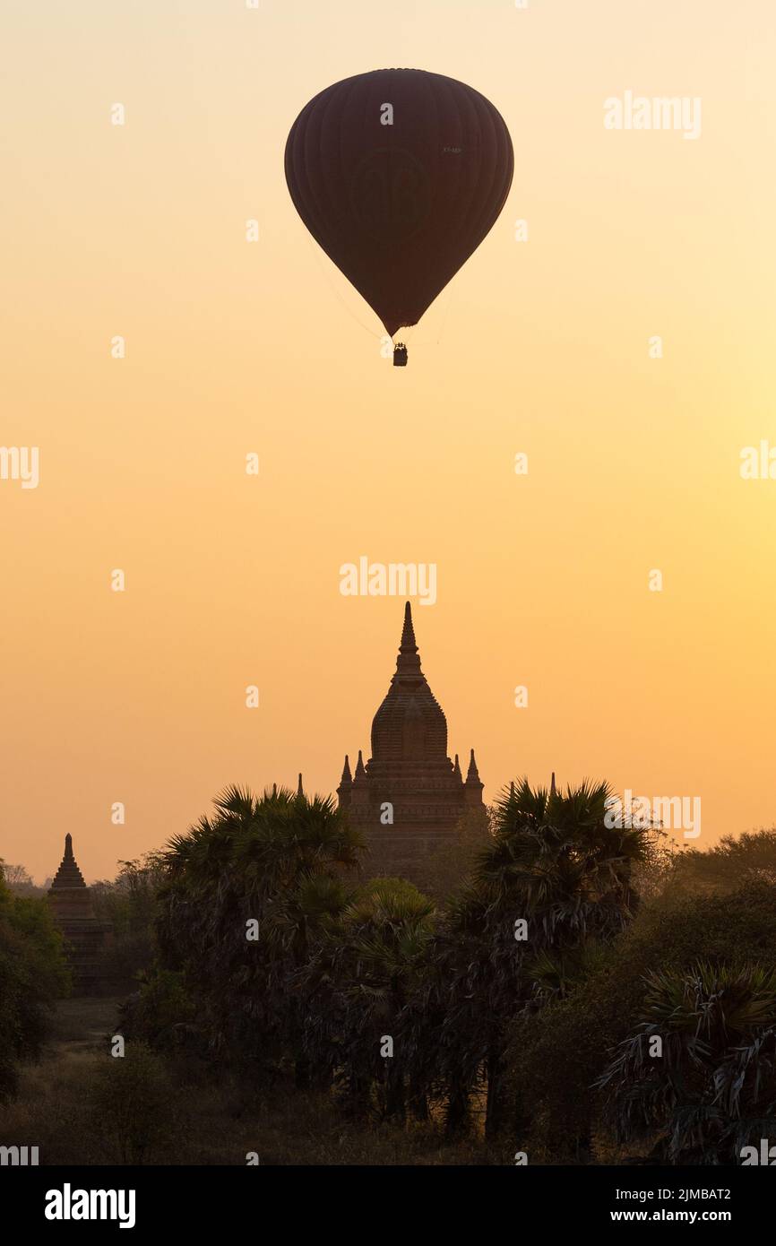 A scenic sunrise with a hot air balloon in Old Bagan, Myanmar (Burma ...