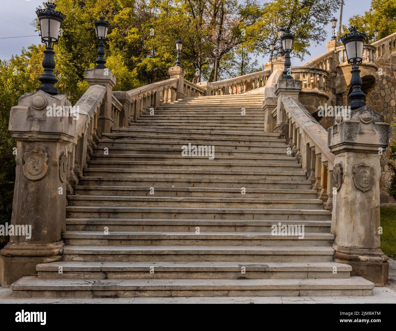 A low-angle closeup of a long ancient stone stairway with black ...