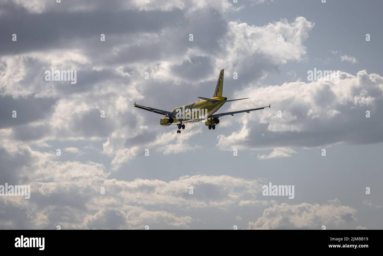 An airplane flying up in the cloudy blue sky Stock Photo - Alamy
