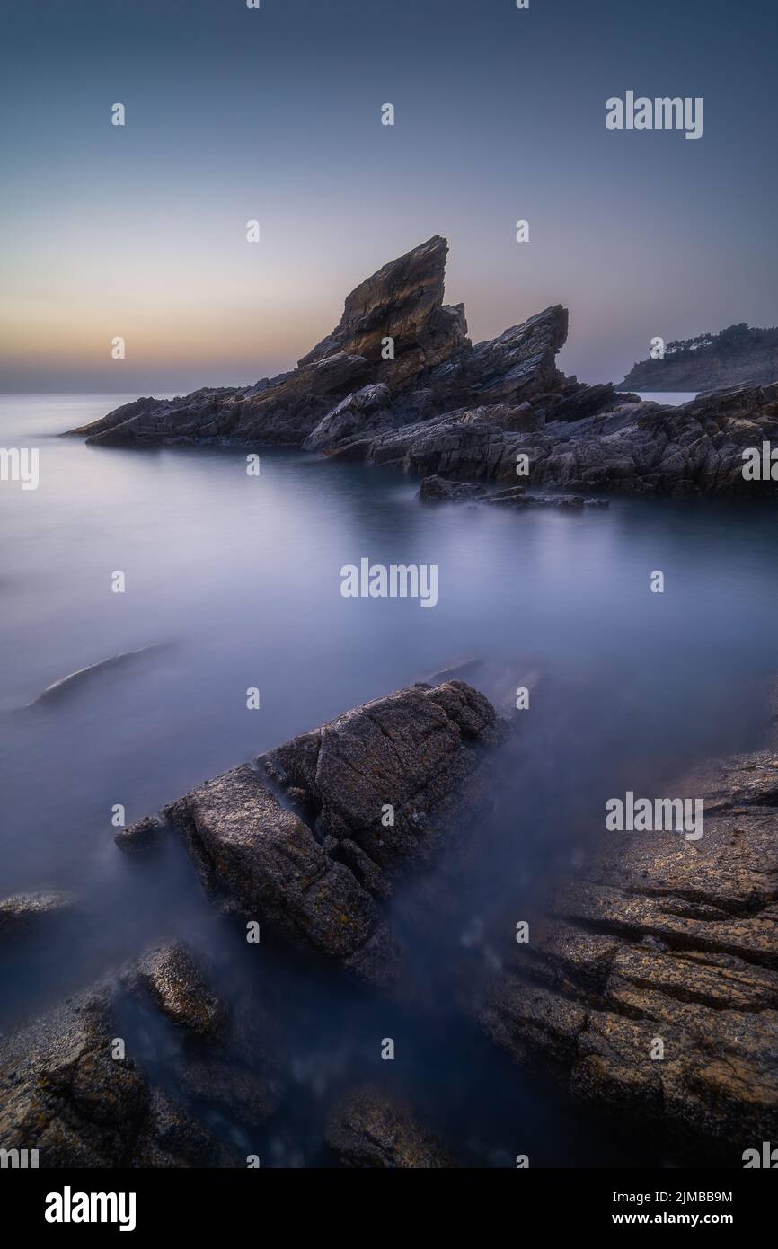An amazing shot of rocky beach with splashing sea waves crashing ...