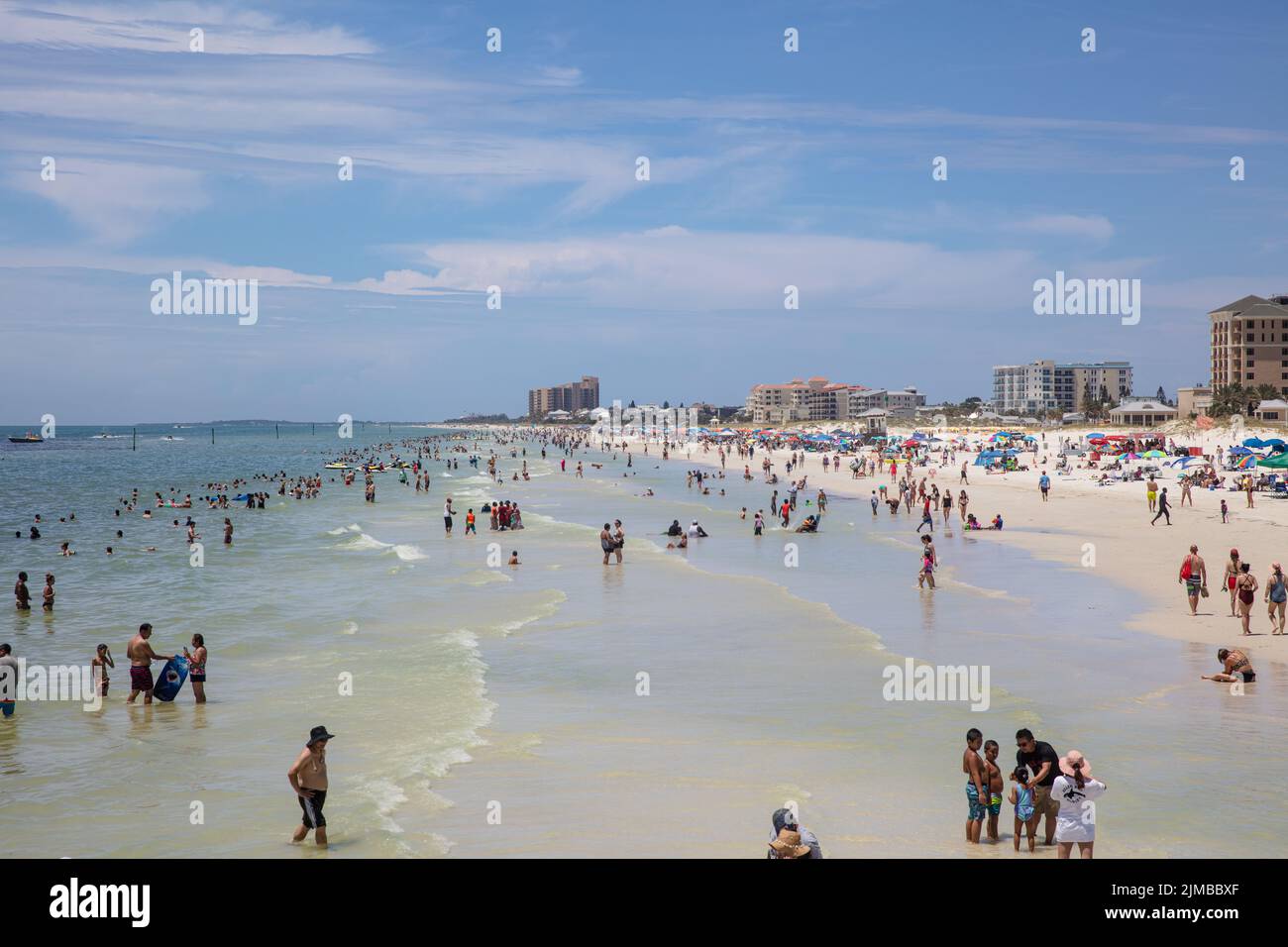 A picturesque view of the Clearwater beach with people swimming in the ...