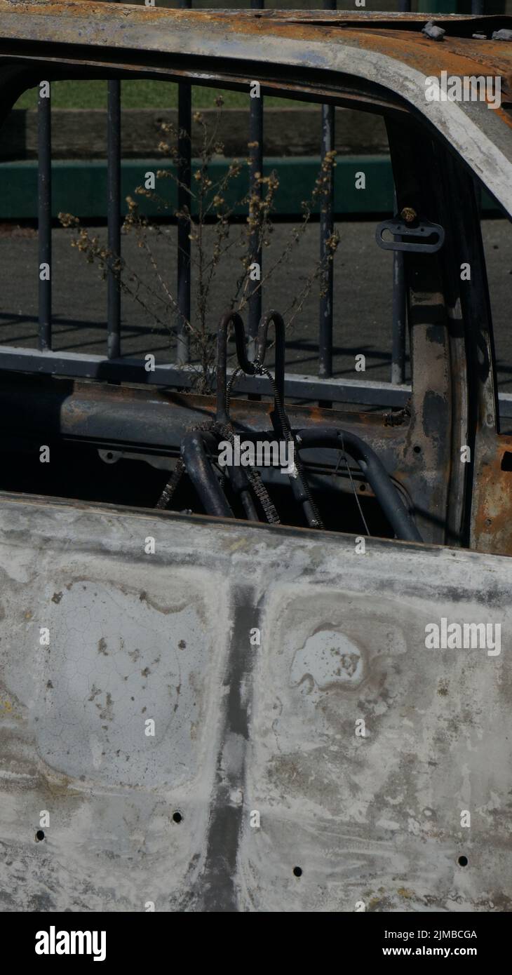 A vertical shot of a metal seat frame in a destroyed rusty car without ...