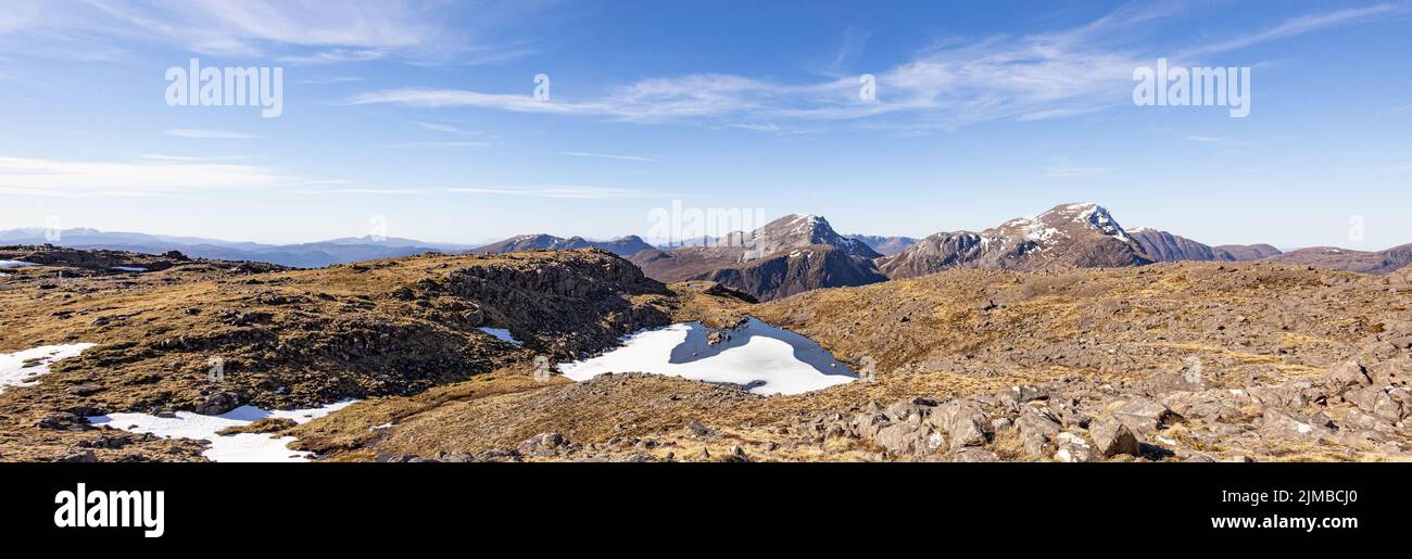 A panoramic shot of a mountain range with frozen lakes and a skyline ...