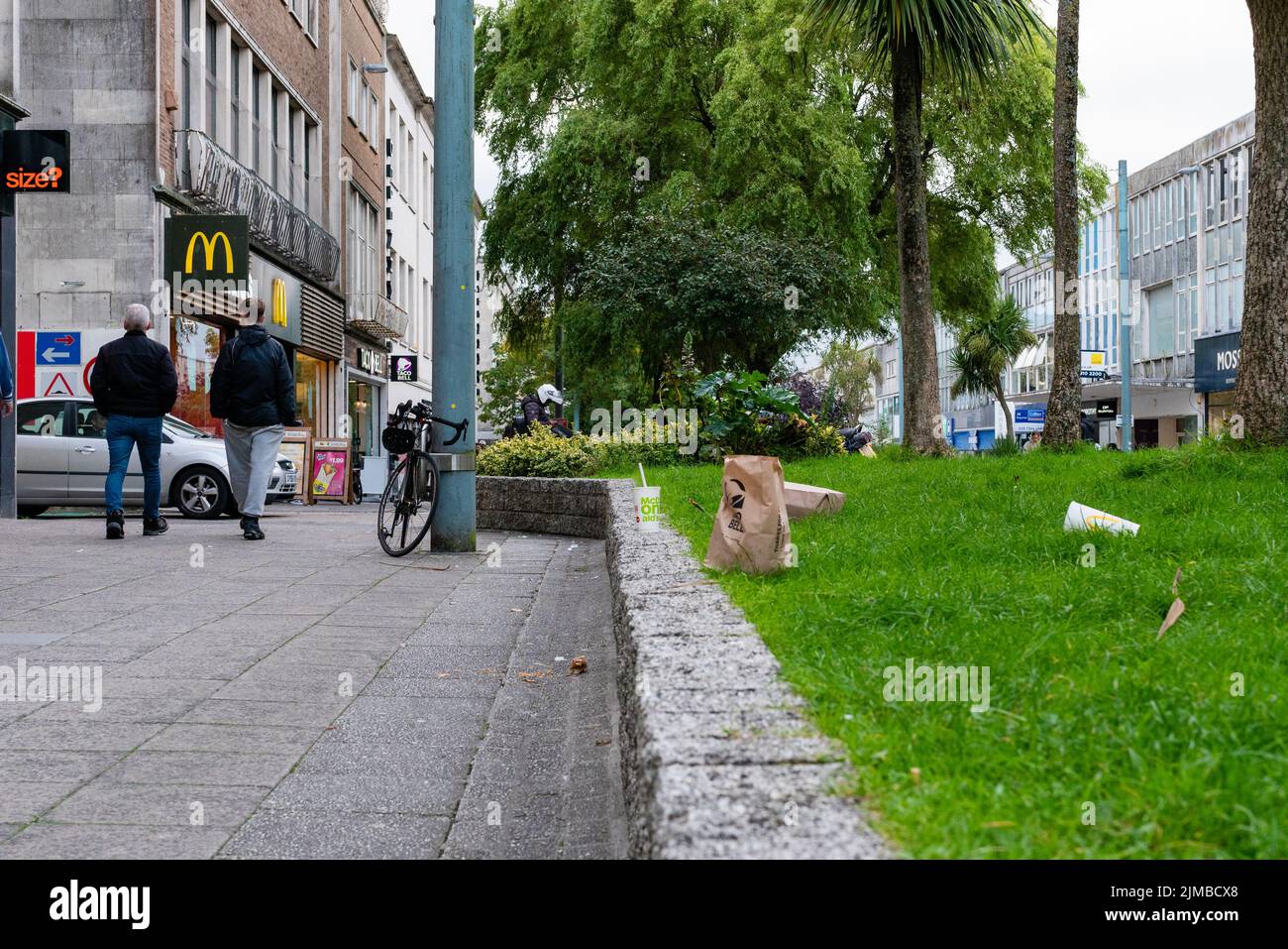 Discarded fast food wrappers, paper bags and cups litter the street in ...