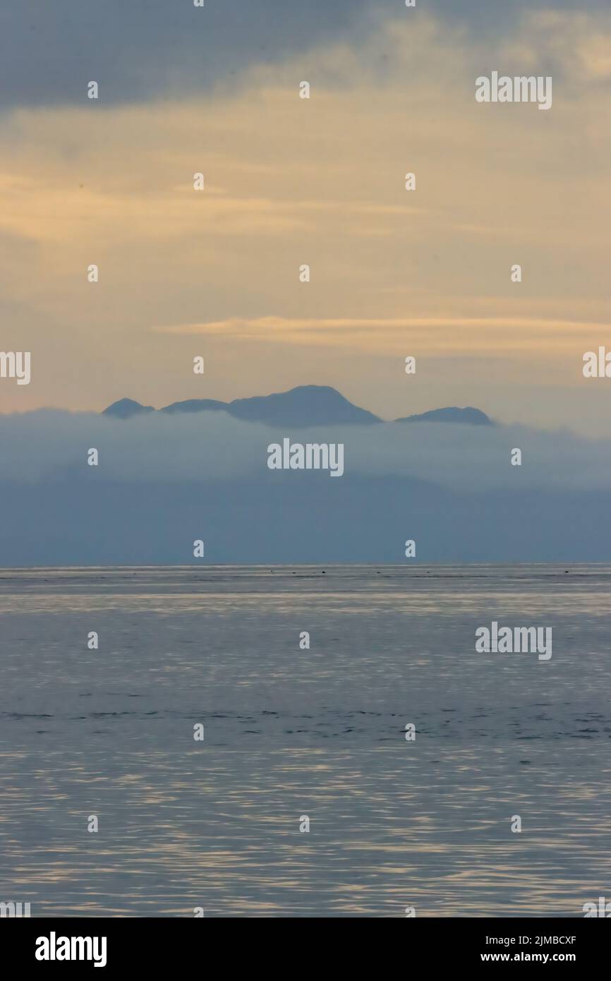 A beautiful view of a calm sea and mountains in a background Stock ...