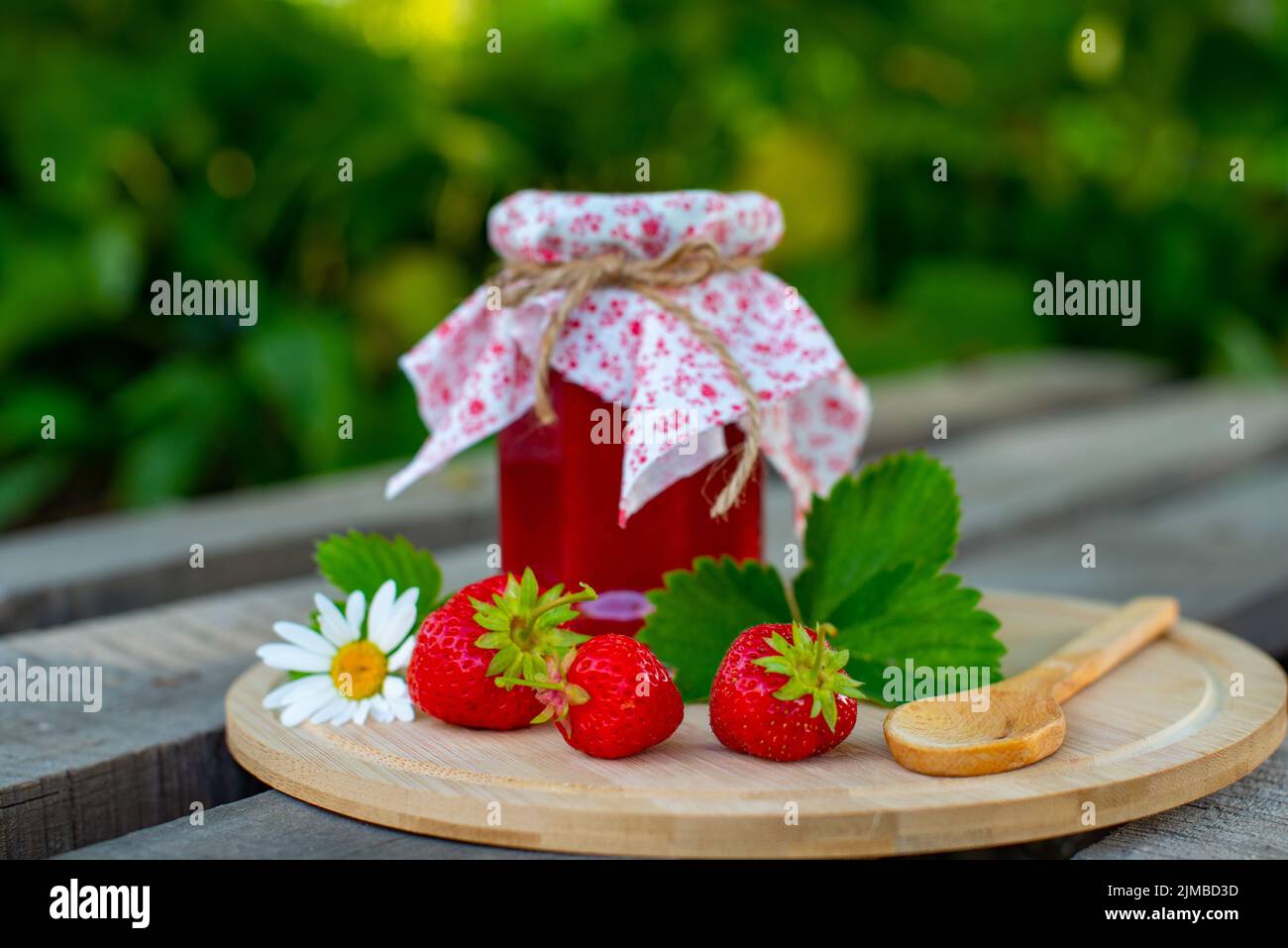 a jar of strawberry jam stands on a board Stock Photo - Alamy