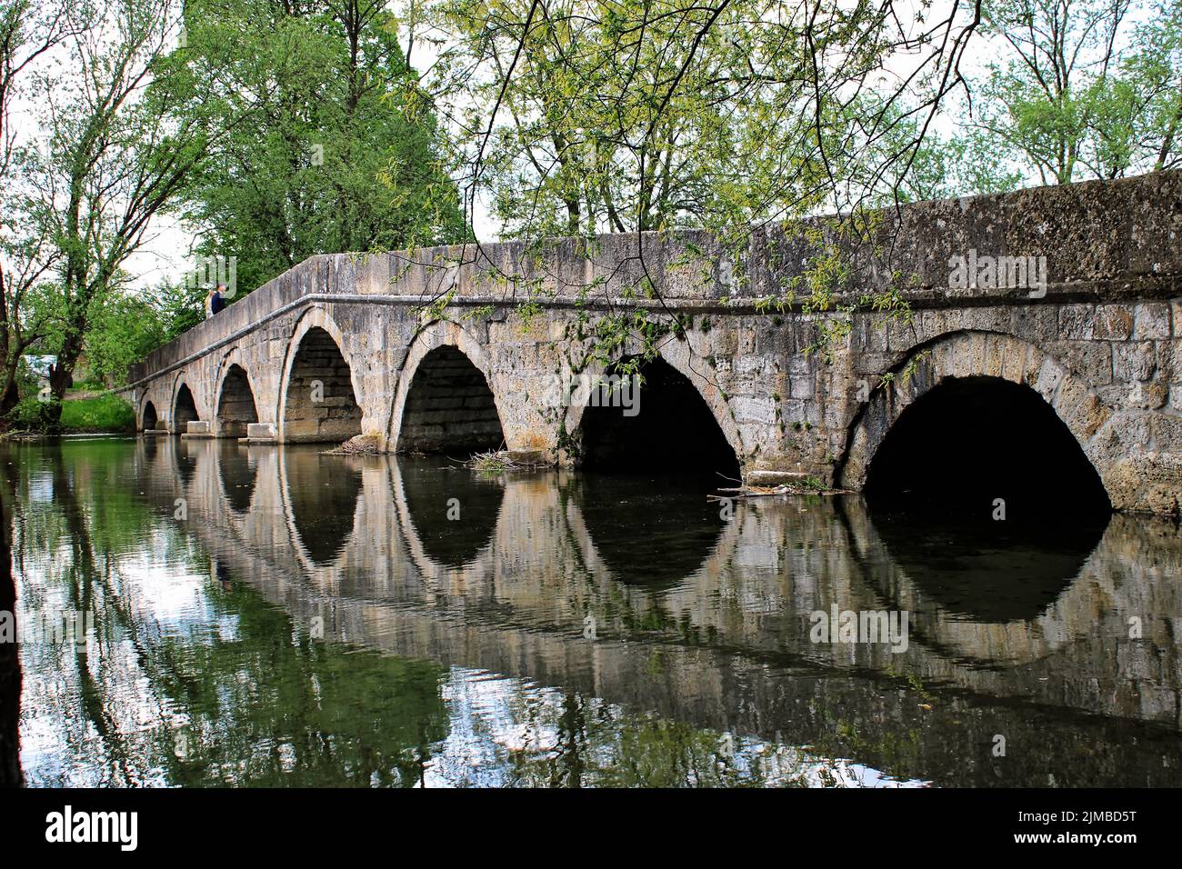 A beautiful view of the Rimski Most in Sarajevo with trees reflected in ...