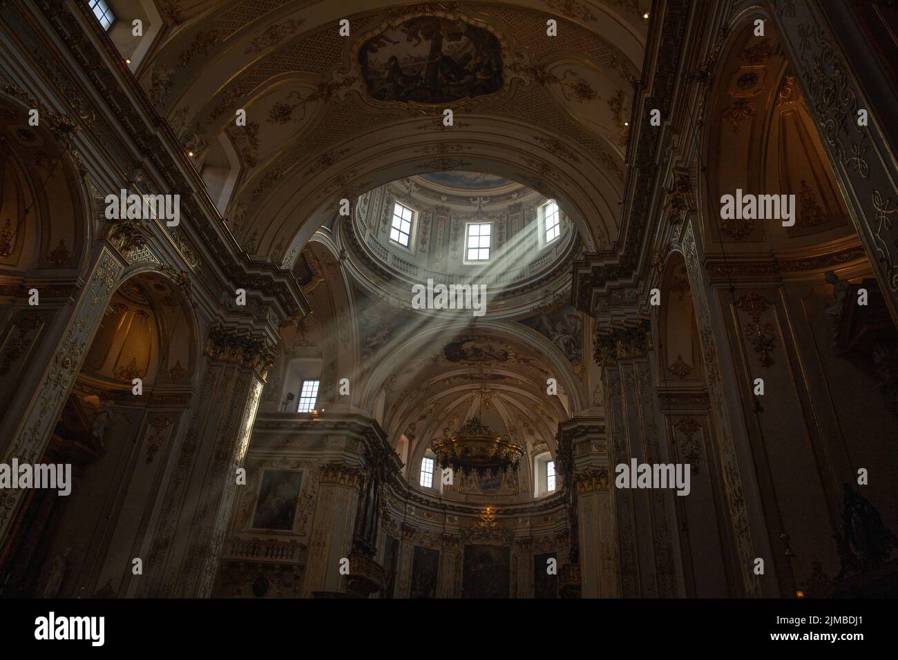 A low angle shot of sunlight in the interior of a cathedral with gilded ...