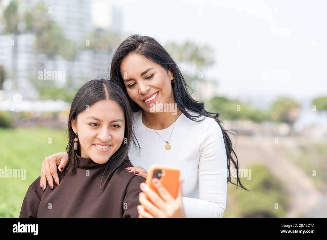 Portrait with selective focus on two friends taking a selfie together ...