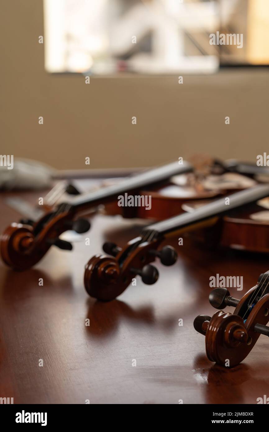 Vertical photo of three violins in musical instrument repair workshop ...