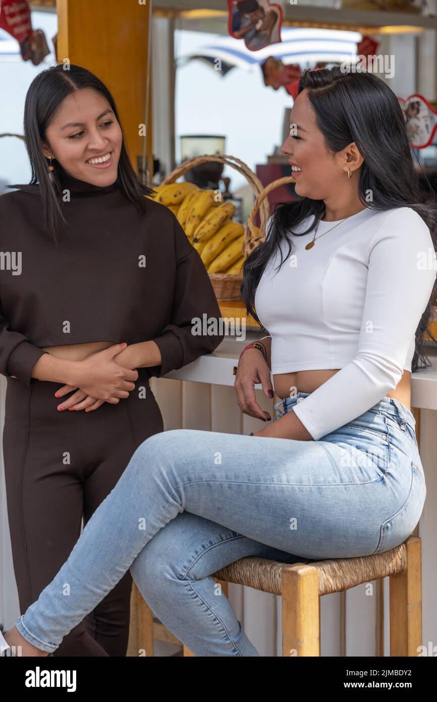 Vertical photo of happy friends sitting in a viewpoint while smiling ...