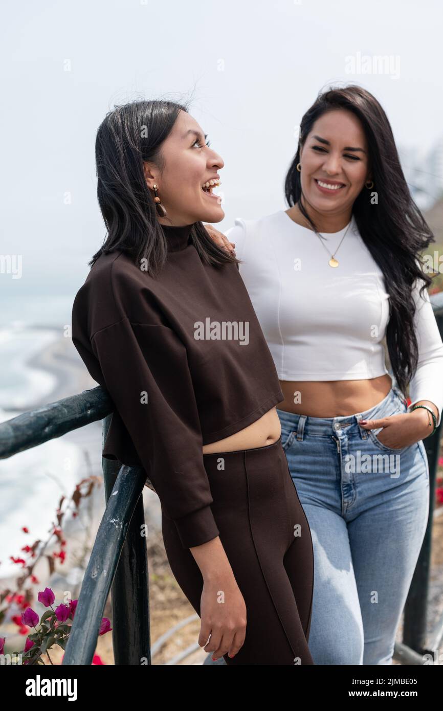 Vertical photo of two women having fun in the viewpoint of Miraflores ...
