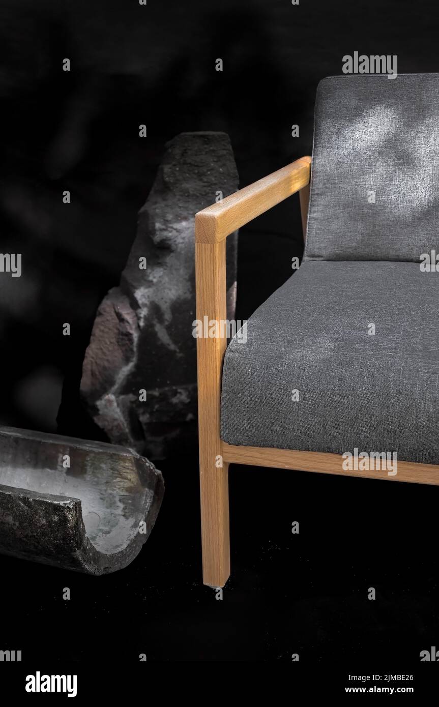 A vertical shot of a chair with a rock on the ground on the black ...