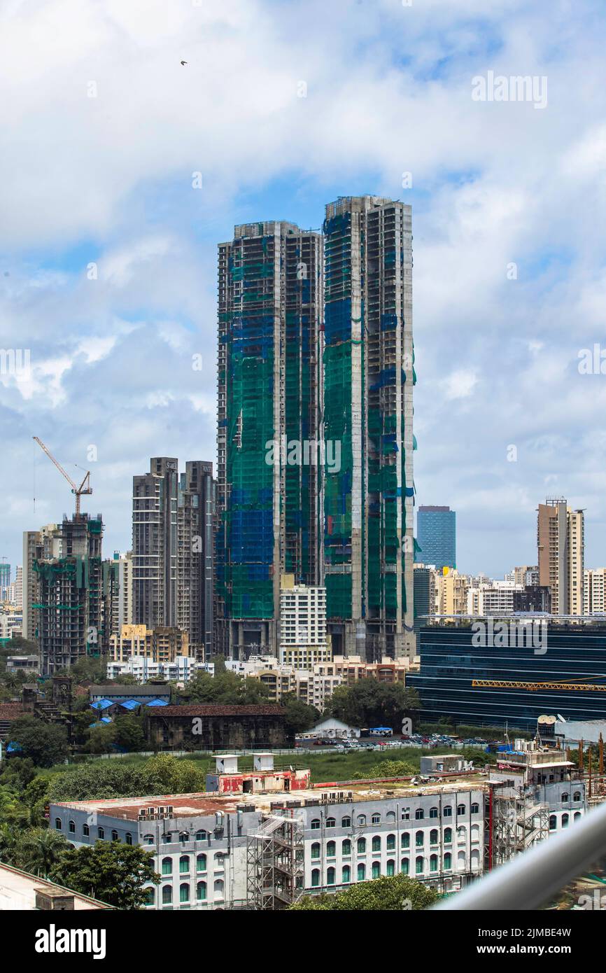 High building under construction. Side with cranes, City buildings and ...