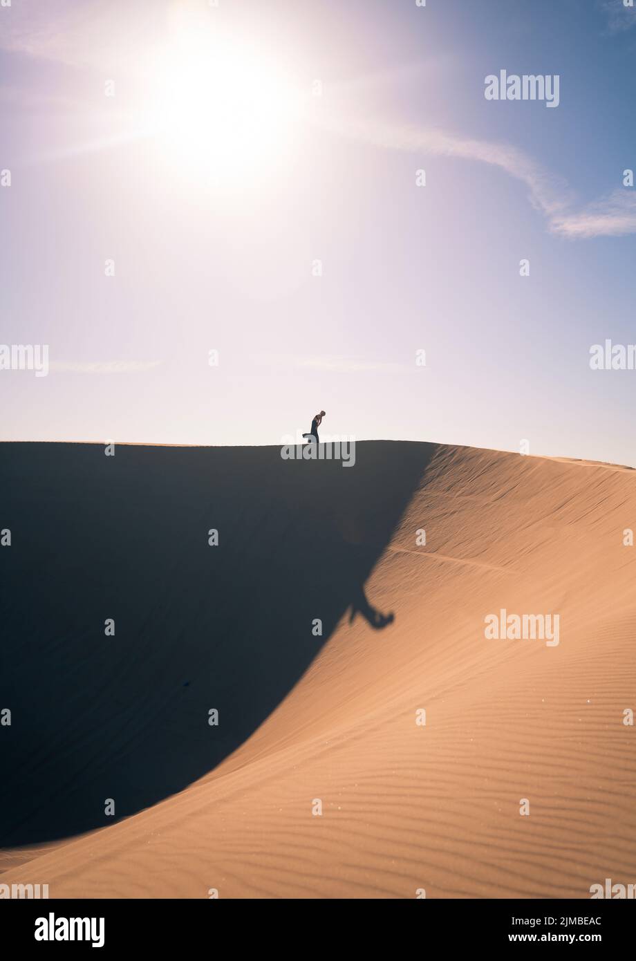 The vertical view of a woman arching back to the sun standing on the ...