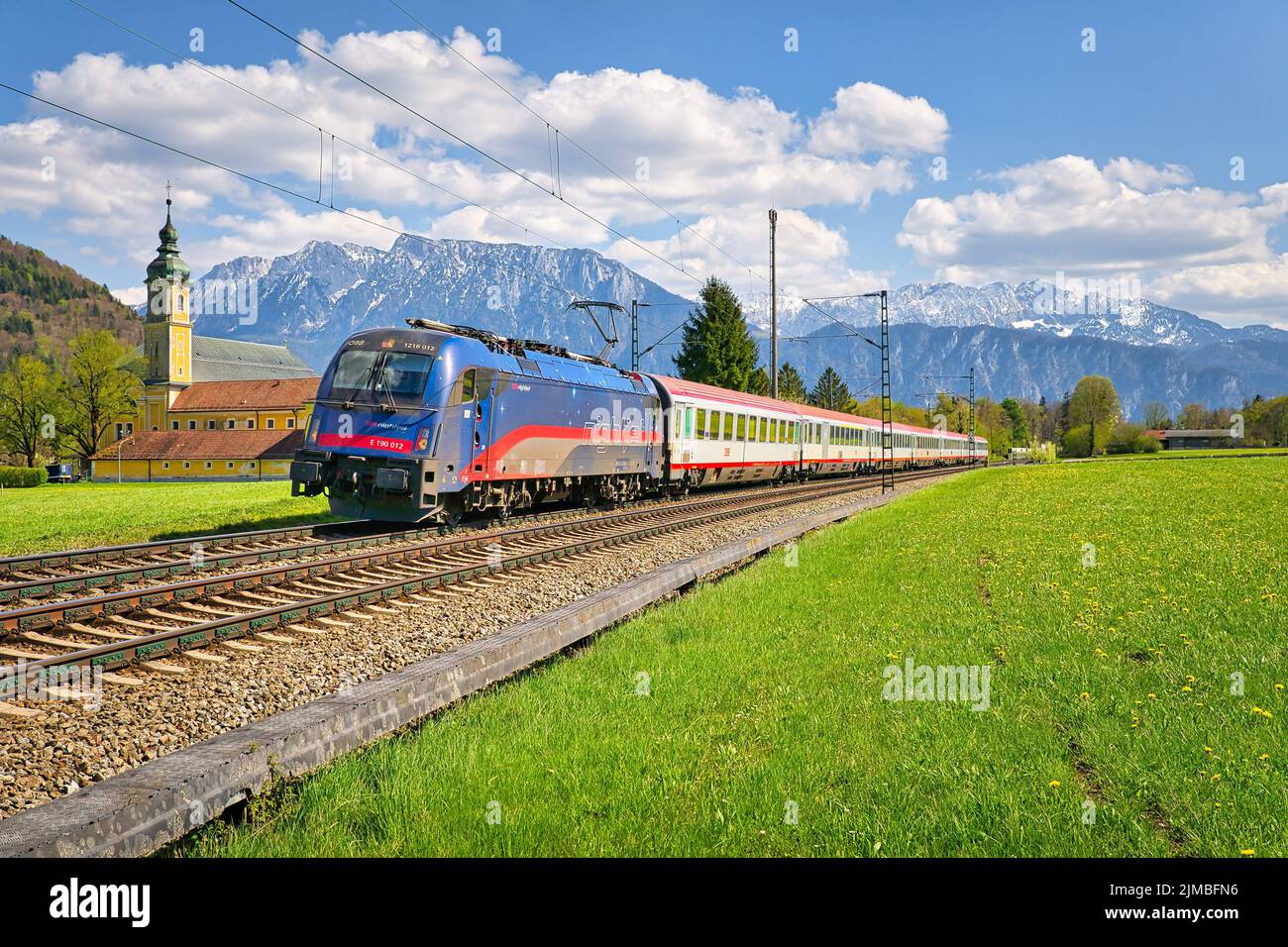 A Eurocity train on its way to Munich through lush green fields Stock ...