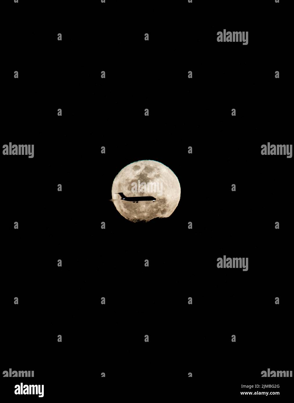 An airplane flying against full moon in night sky Stock Photo - Alamy