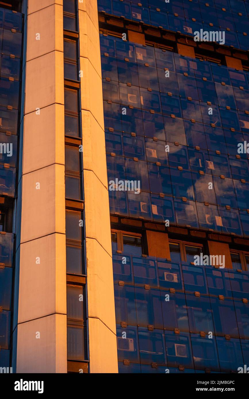 A tall glass building with the sunsets reflection Stock Photo - Alamy