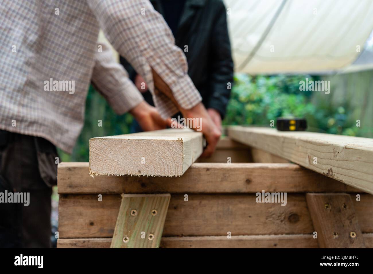A close-up shot of building foundations two carpenters working on a ...