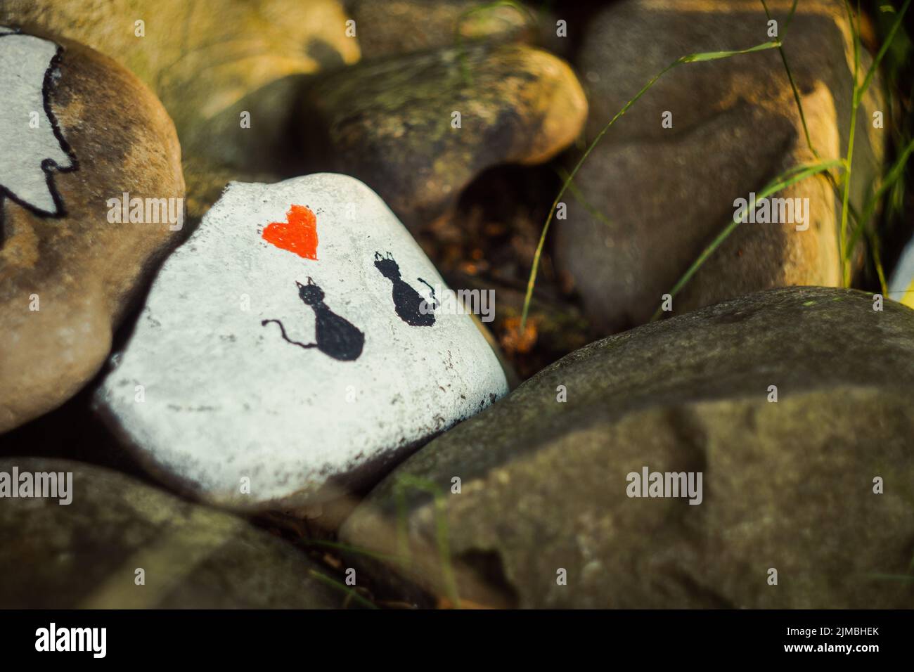A romantic cat couple drawing on a stone on the ground Stock Photo - Alamy
