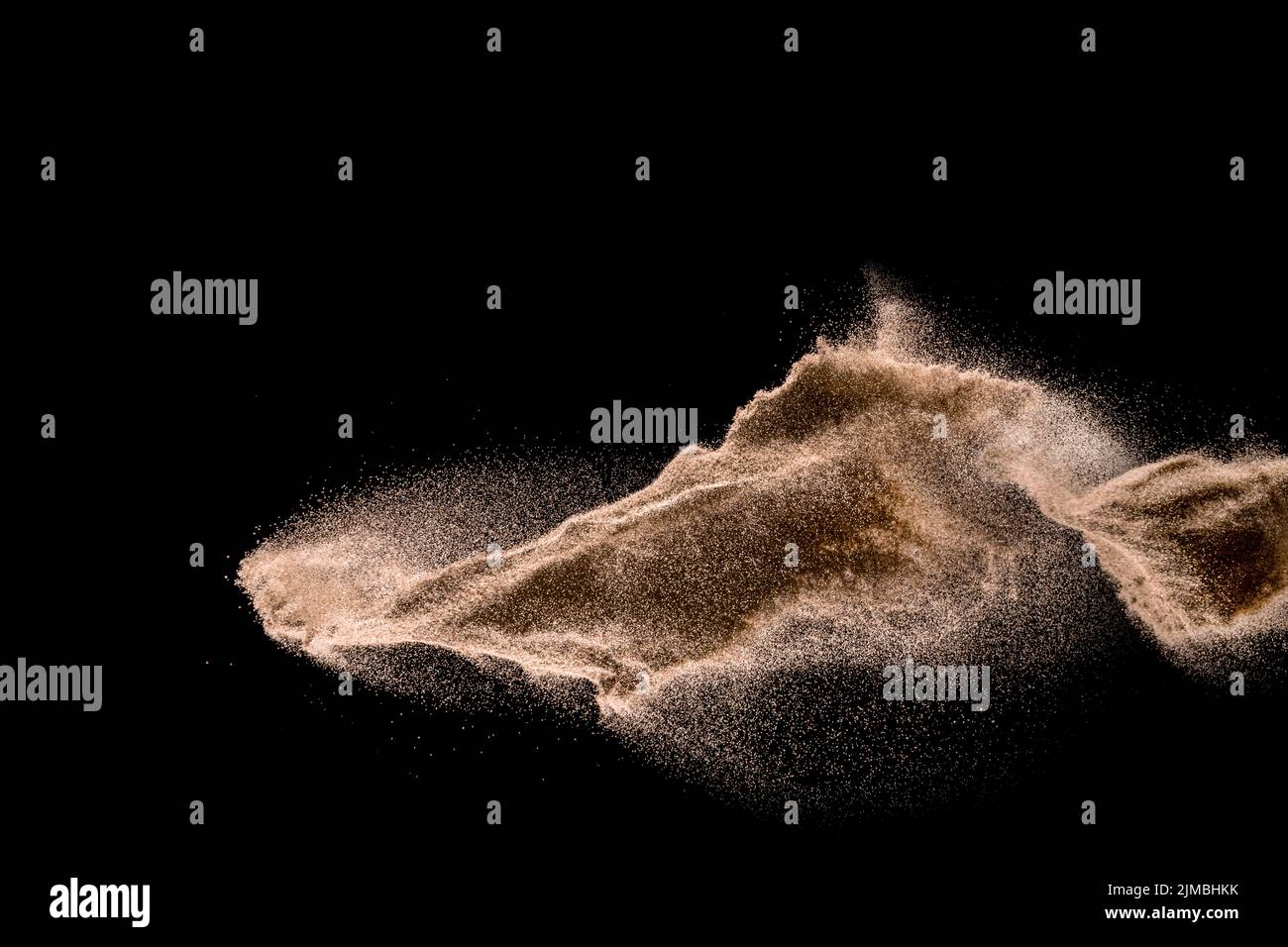 Dry river sand explosion. Golden colored sand splash agianst dark ...