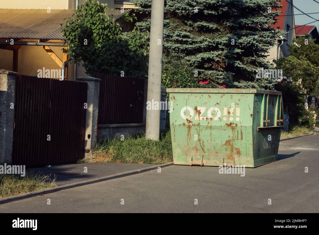 A rusted trash bin on the street near houses Stock Photo - Alamy