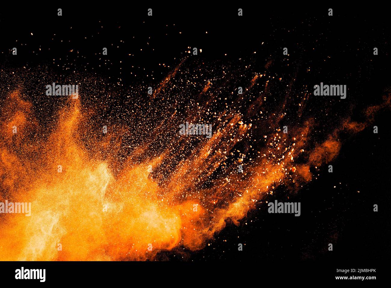 Abstract orange powder explosion on black background. Freeze motion of ...