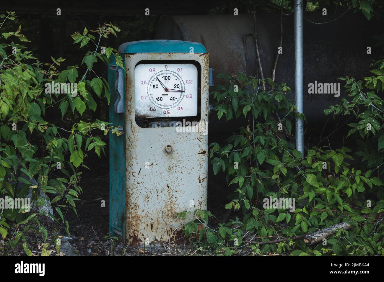 Old rusty abandoned gas station overgrown with grass and trees Stock ...