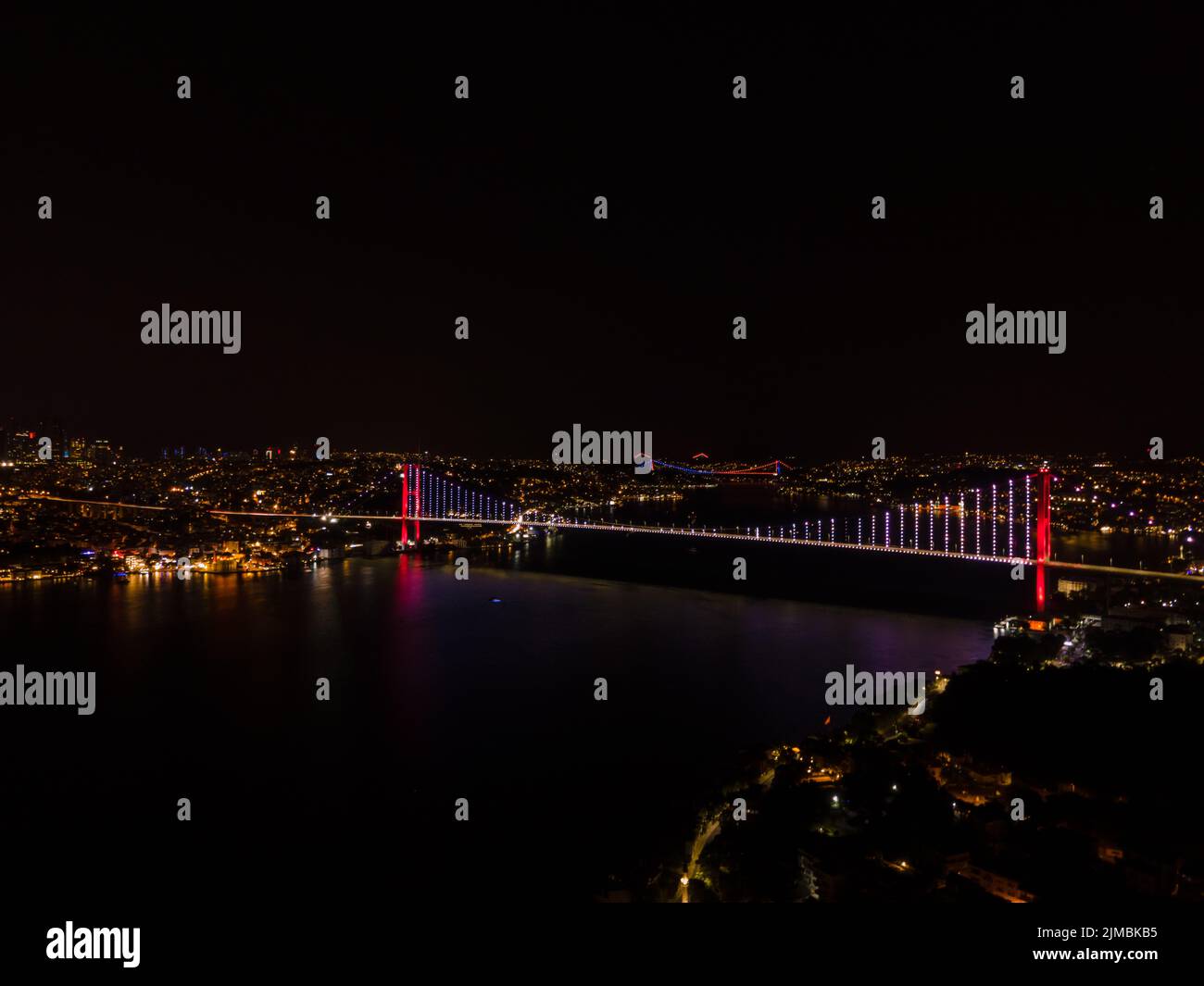 The aerial view of the glowing bridges above Bosphorus Strait at night ...