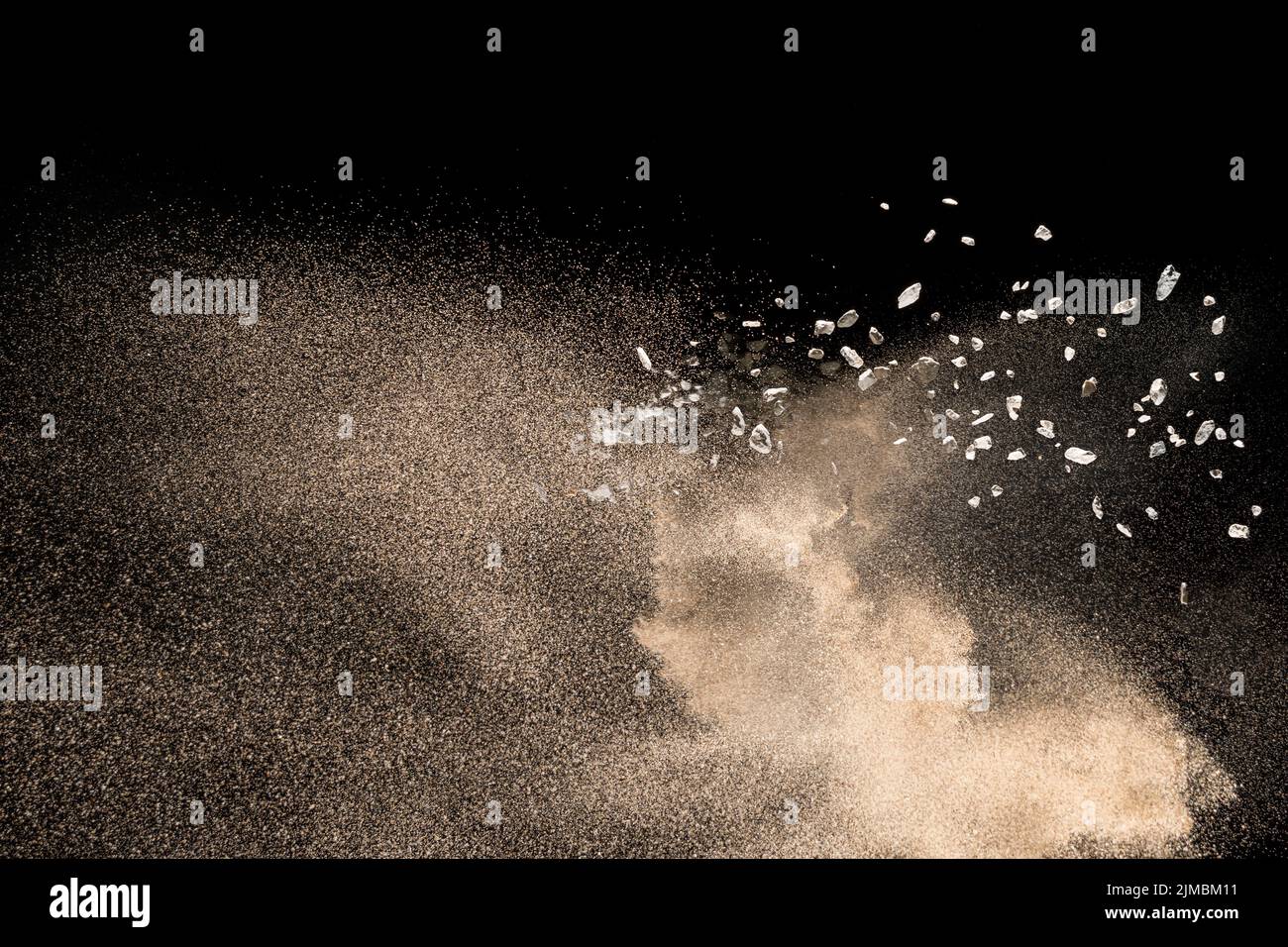 Dry river sand with stone explosion. Golden colored sand splash against ...