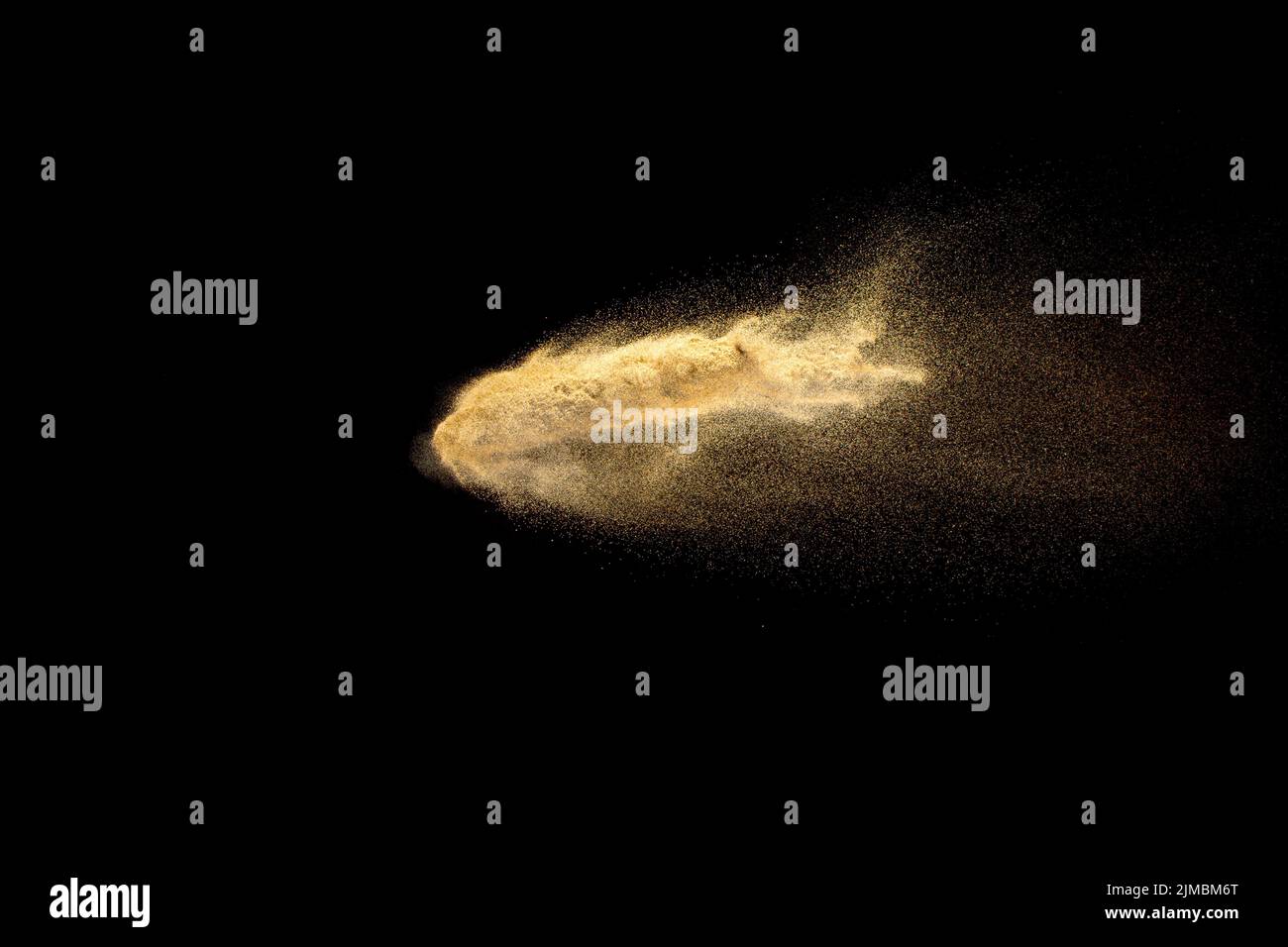 Abstract sand cloud. Golden colored sand splash against dark background ...